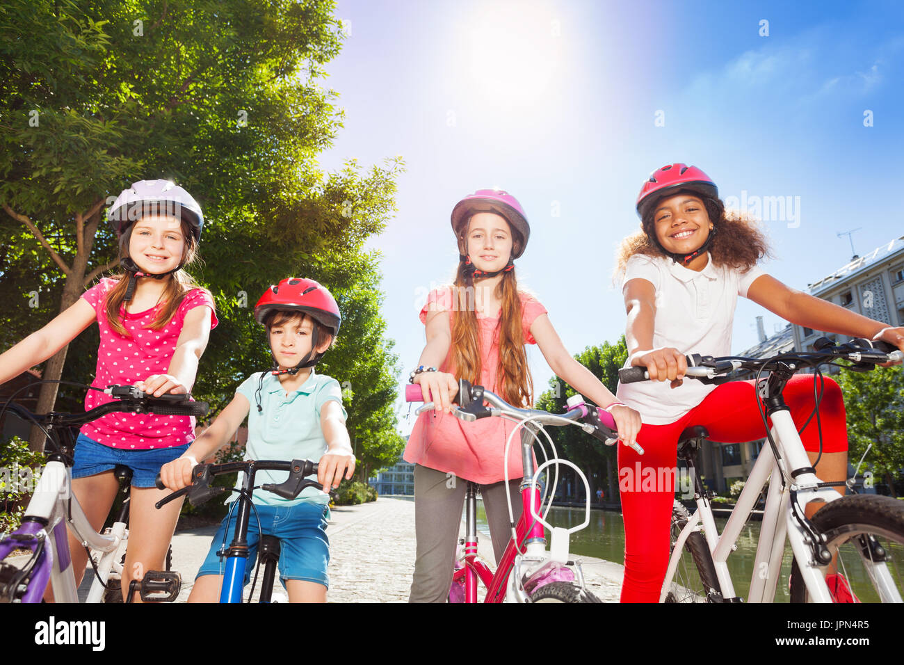 Happy bike riders standing together at summer park Stock Photo - Alamy