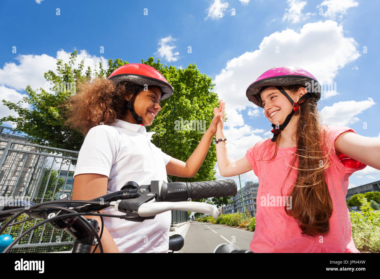 Happy bike riders giving high five after racing Stock Photo - Alamy