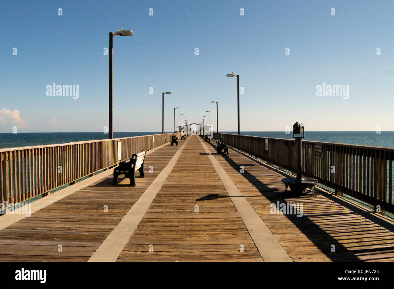 A long wooden pier with benches and an observation telescope Stock ...