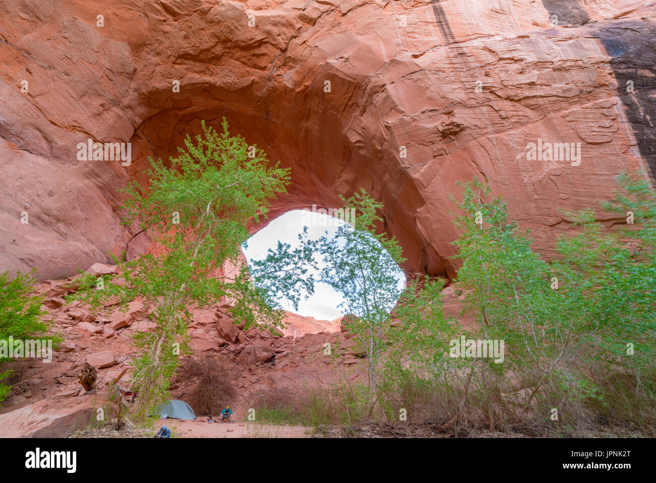 A view of backpackers relaxing beneath Jacob Hambline Arch in Coyote ...