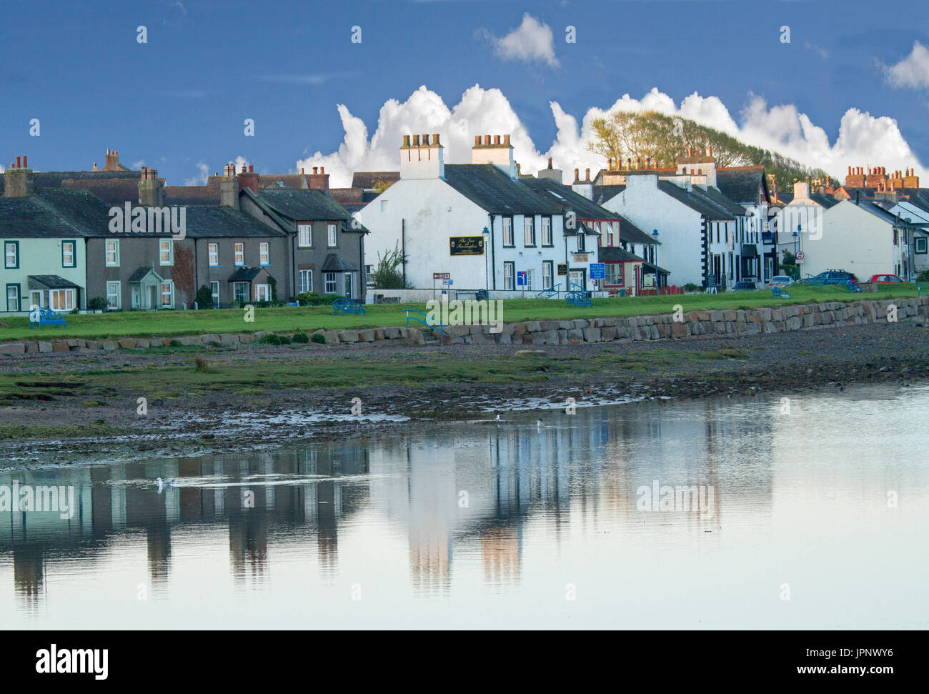 Row of waterfront houses, at coastal village of Ravenglass, reflected ...