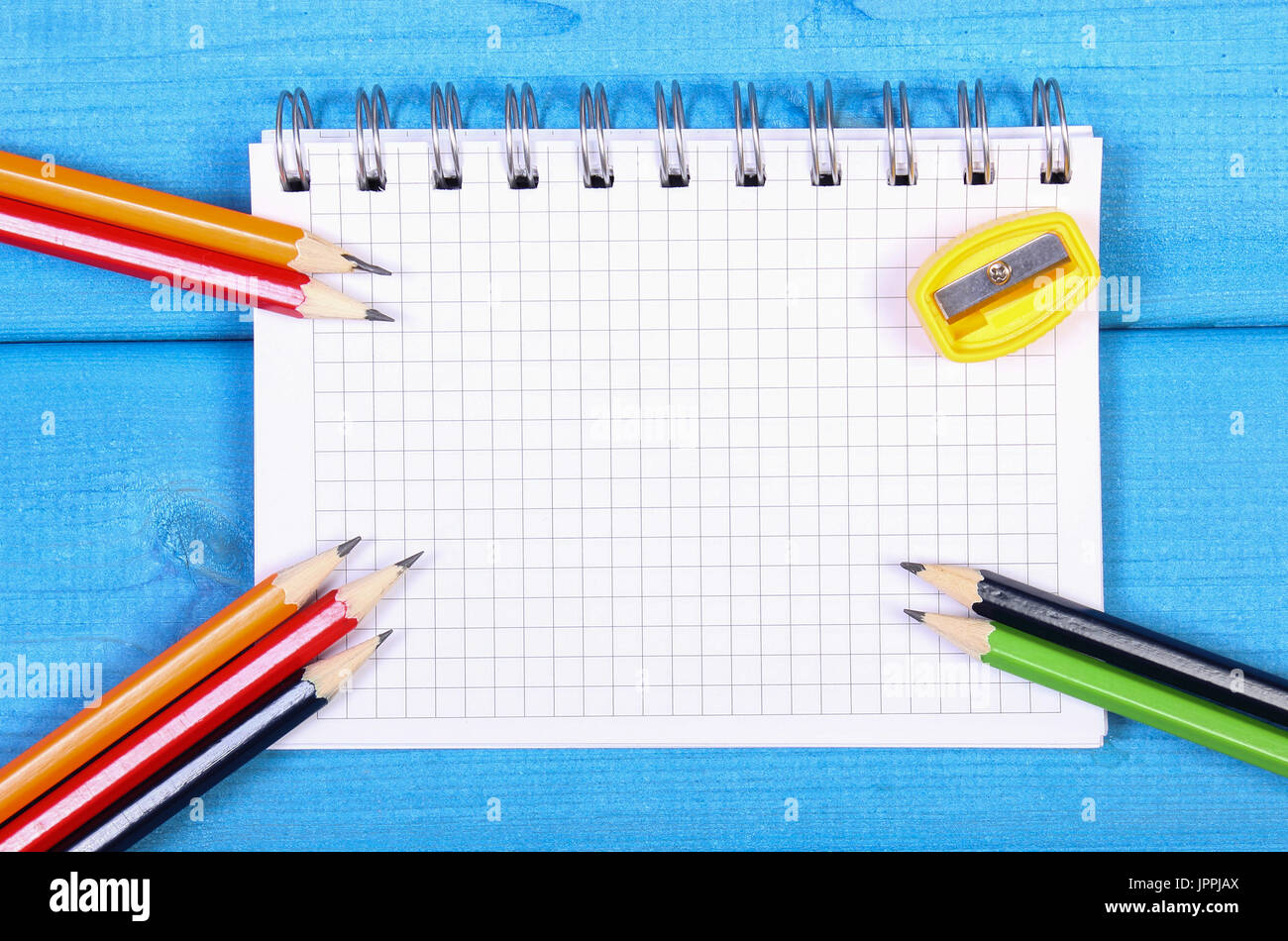 Colorful crayons, sharpener and notepad for notes on boards, concept of ...