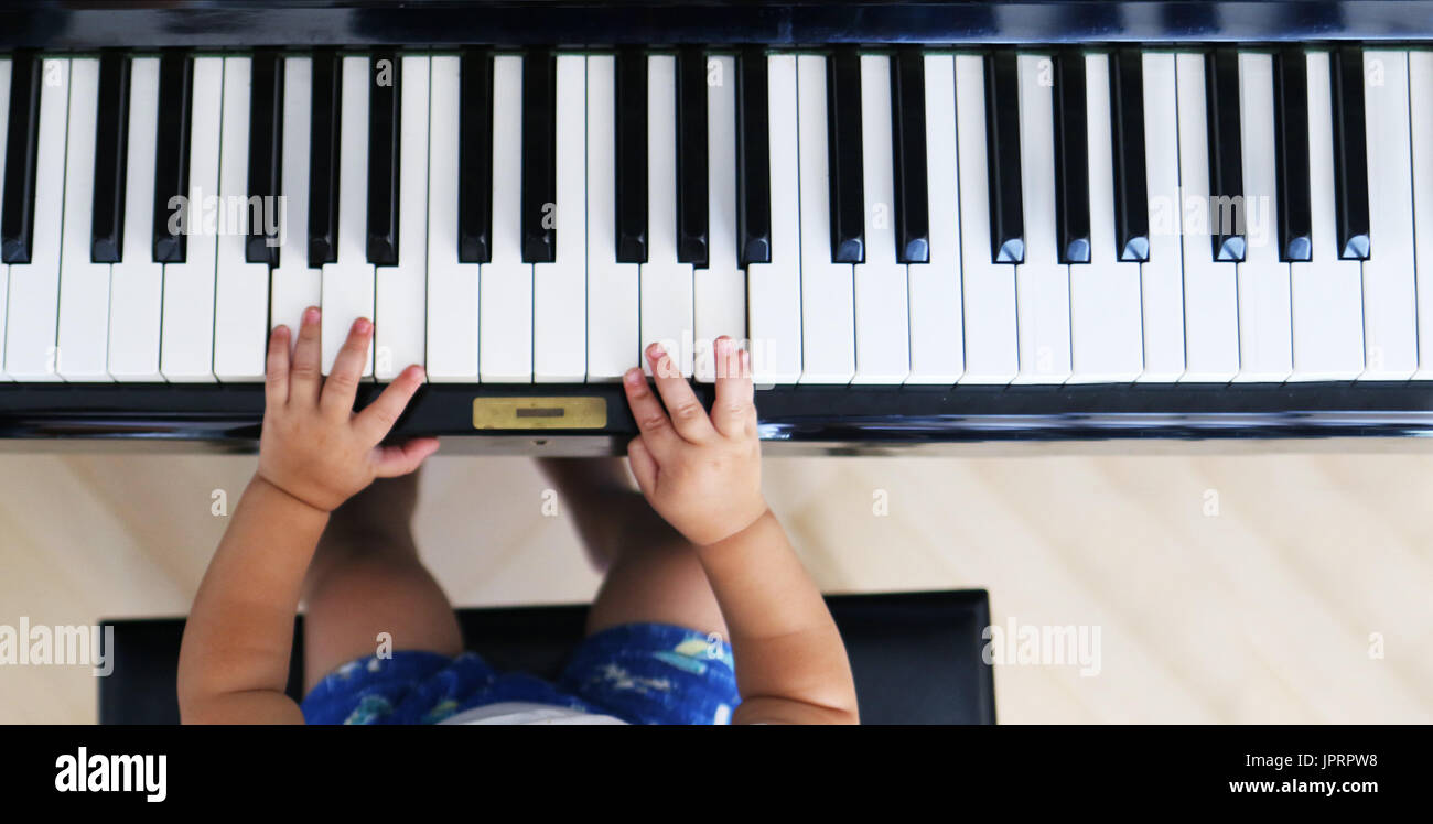 Toddler learning to play piano Stock Photo - Alamy