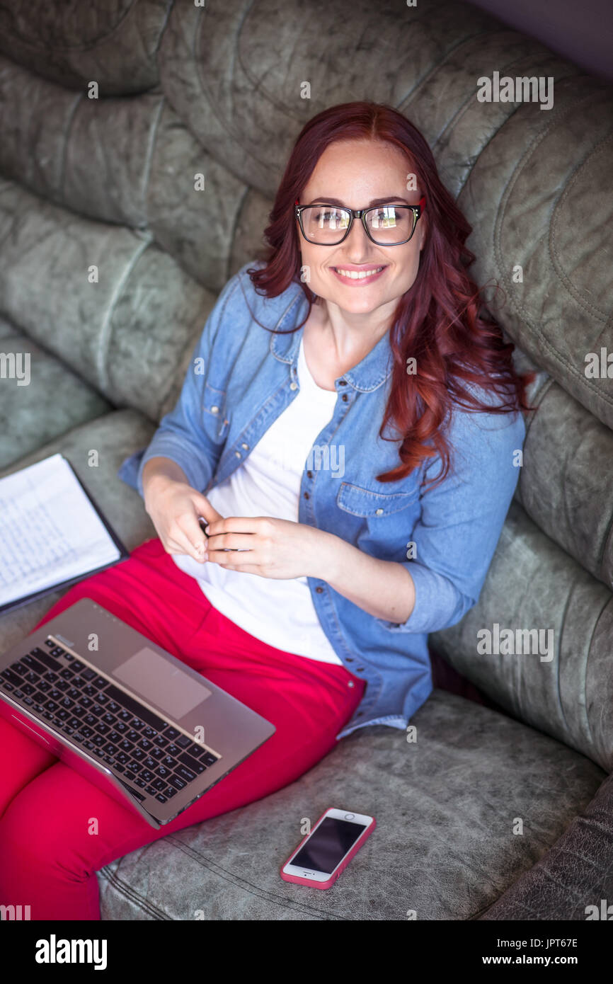 Woman sitting on sofa working hi-res stock photography and images - Alamy