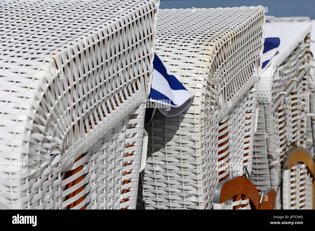 Three roofed beach chairs are shown close up. Side view of these beach ...