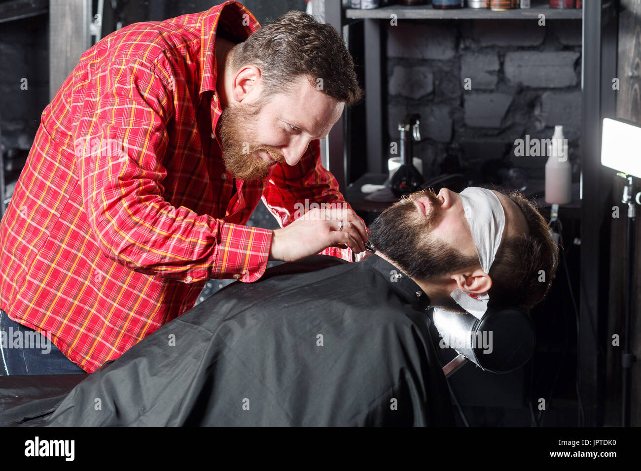Barber making beard haircut using shaver Stock Photo - Alamy