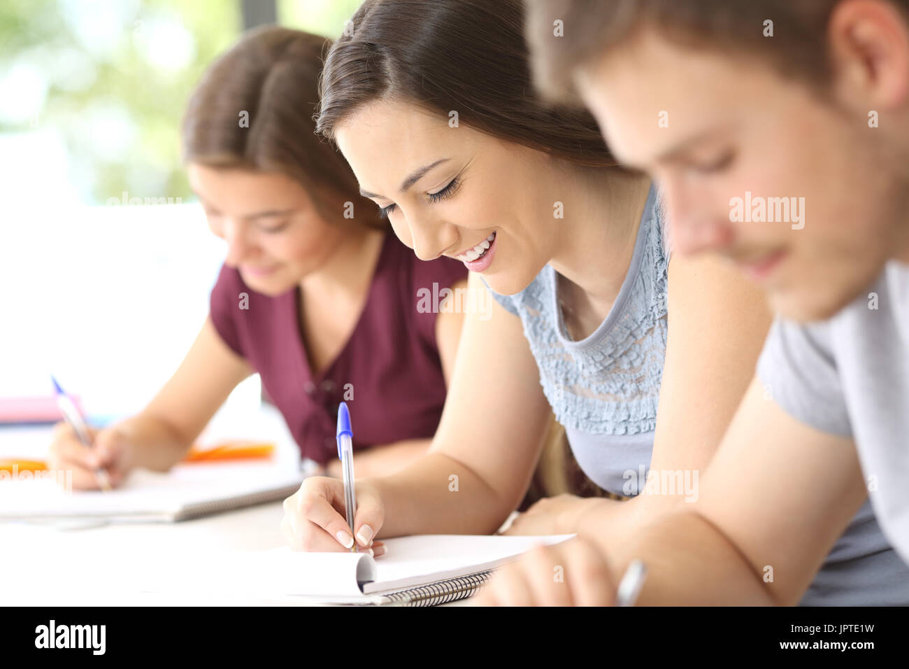 Happy student taking notes during a class in a classroom Stock Photo ...