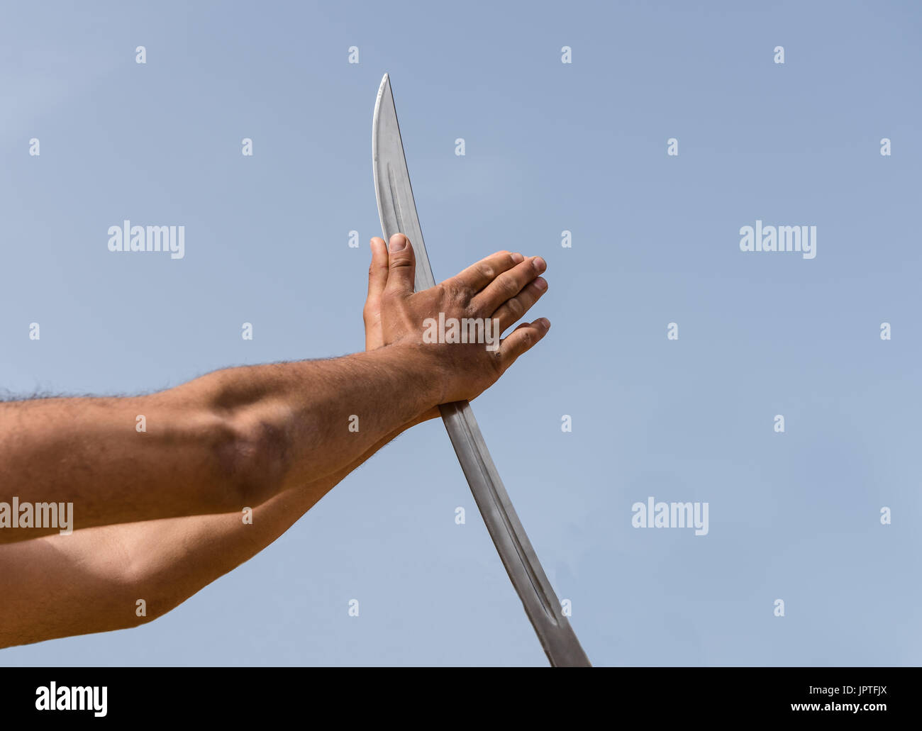 Man stops sword with two hands on the air Stock Photo - Alamy