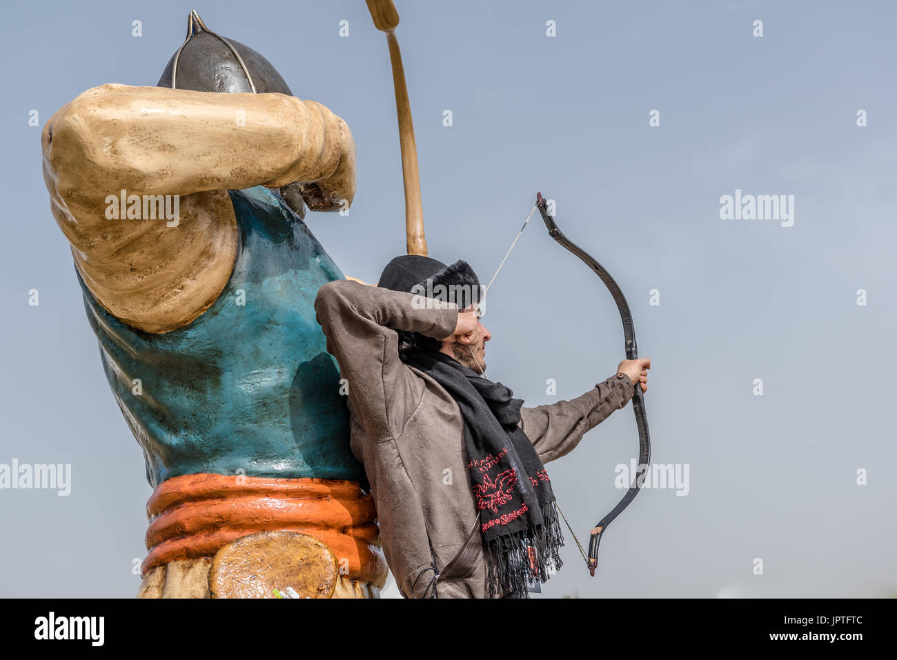 Statue of man archer and Unidentified medieval archer in costumes of ...