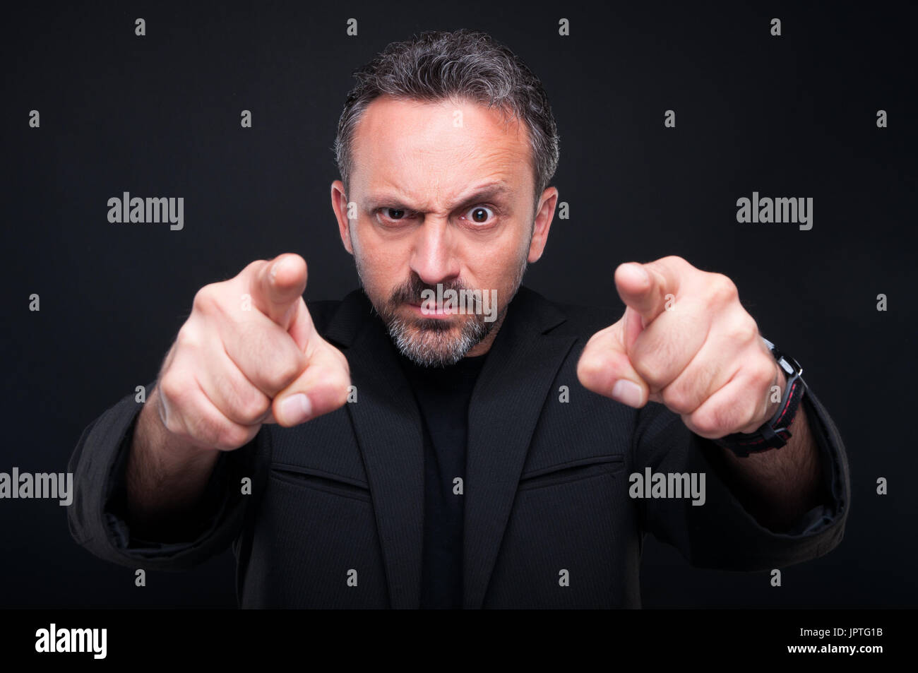 Furious classy man pointing at you with both index fingers on dark ...