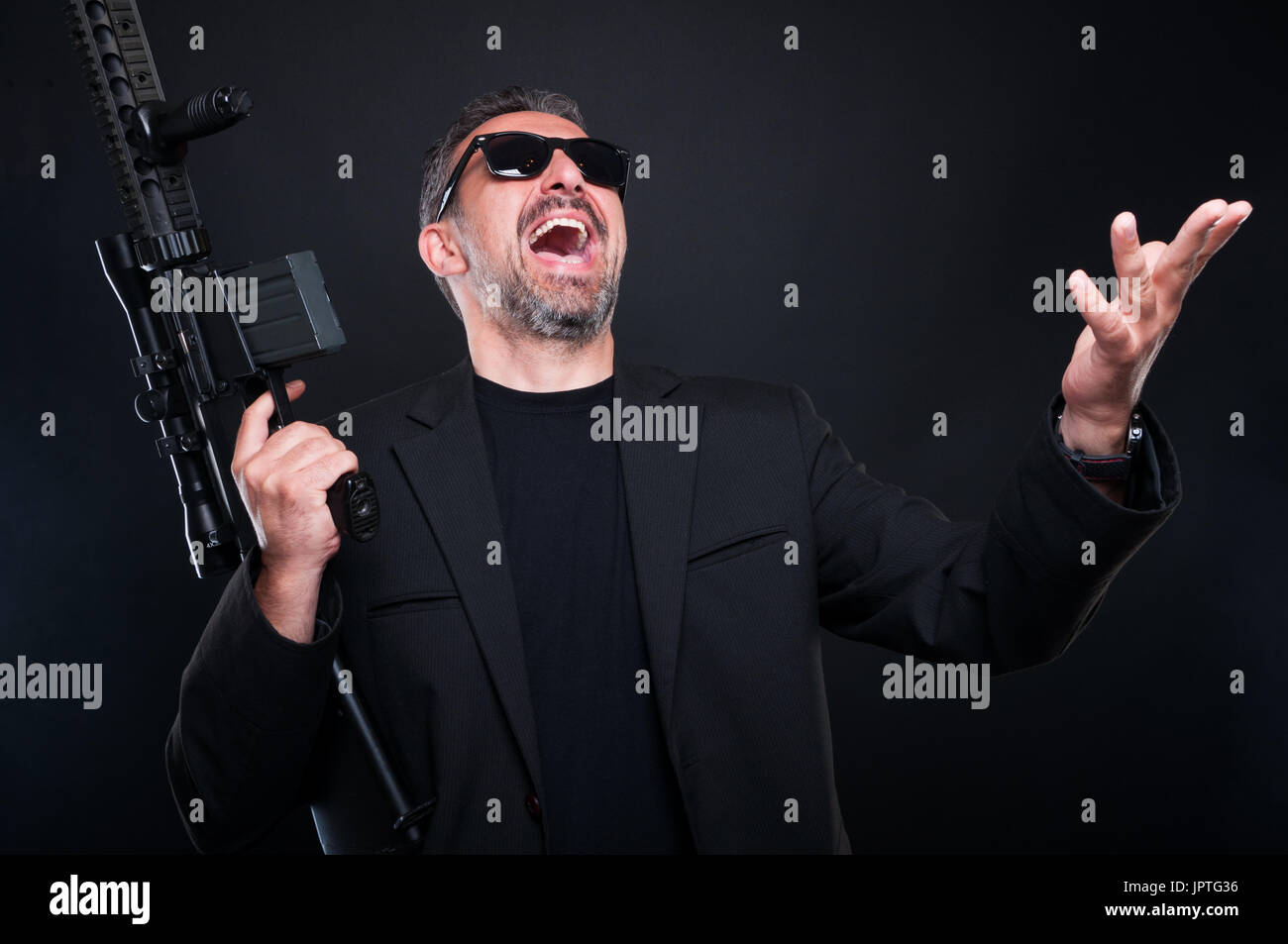 Gangster boss with big rifle having fun and smiling with mouth wide ...