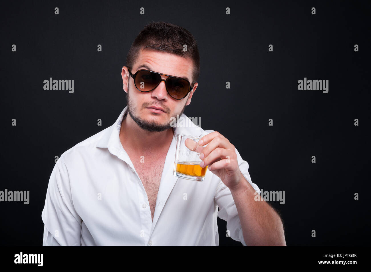 Young mafia guy drinking fine alcohol on dark background Stock Photo ...