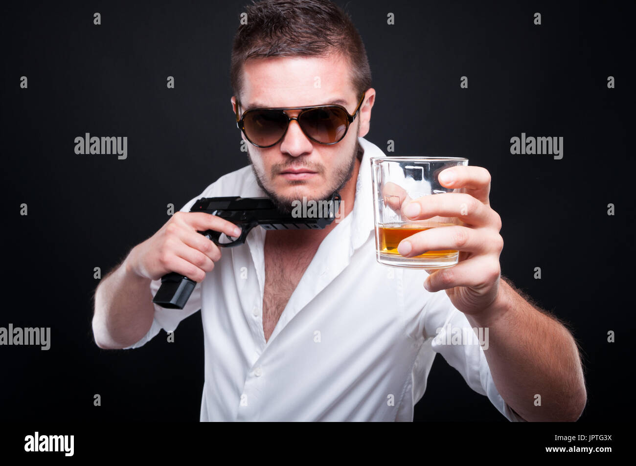 Angry rich gangster doing a kill gesture with armed revolver on dark ...