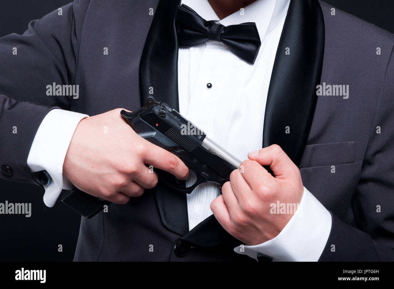 Mafia gangster in suit with gun in closeup as murder or attack concept ...