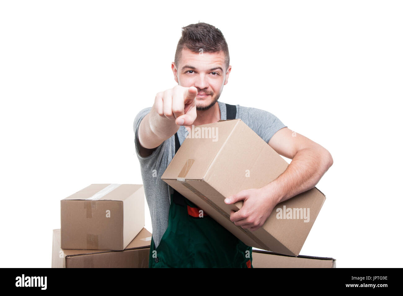 Handsome mover guy holding cardboard box pointing camera and smiling ...