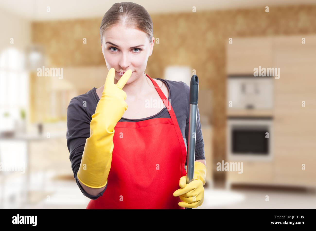 Pretty cleaning lady is keeping eyes on you while brushing the kitchen ...