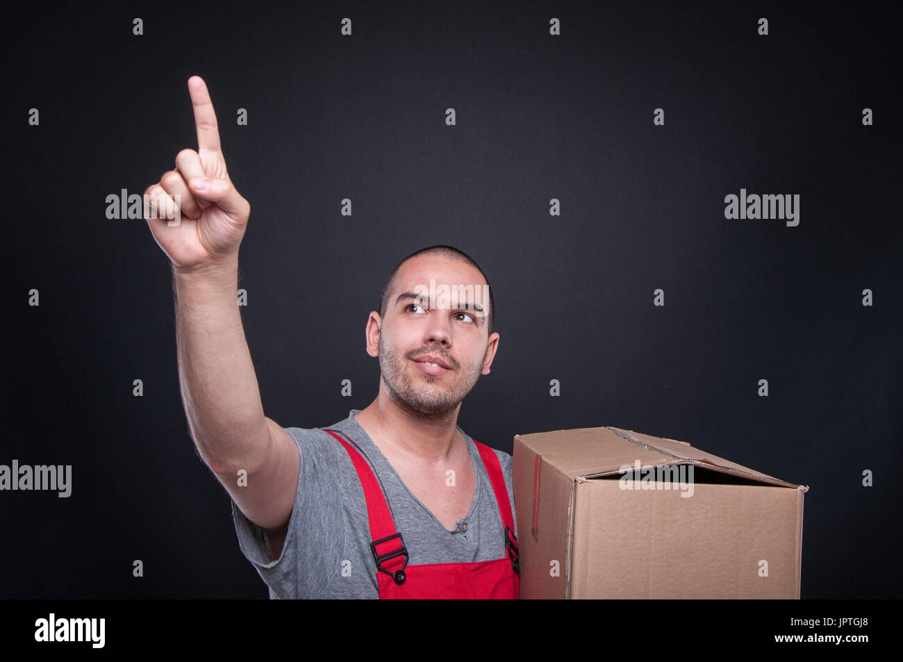 Mover man holding box gesturing touchscreen and smiling on black ...