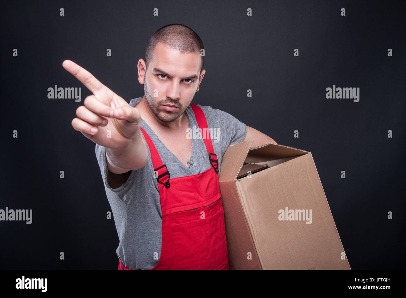 Angry mover man holding box showing no gesture on black background ...