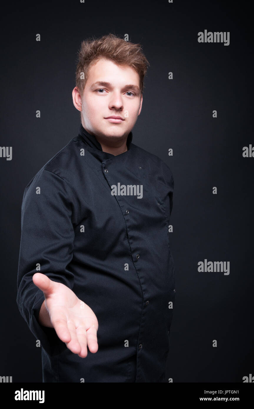 Successful chef giving one hand for shaking or congratulate someone on ...