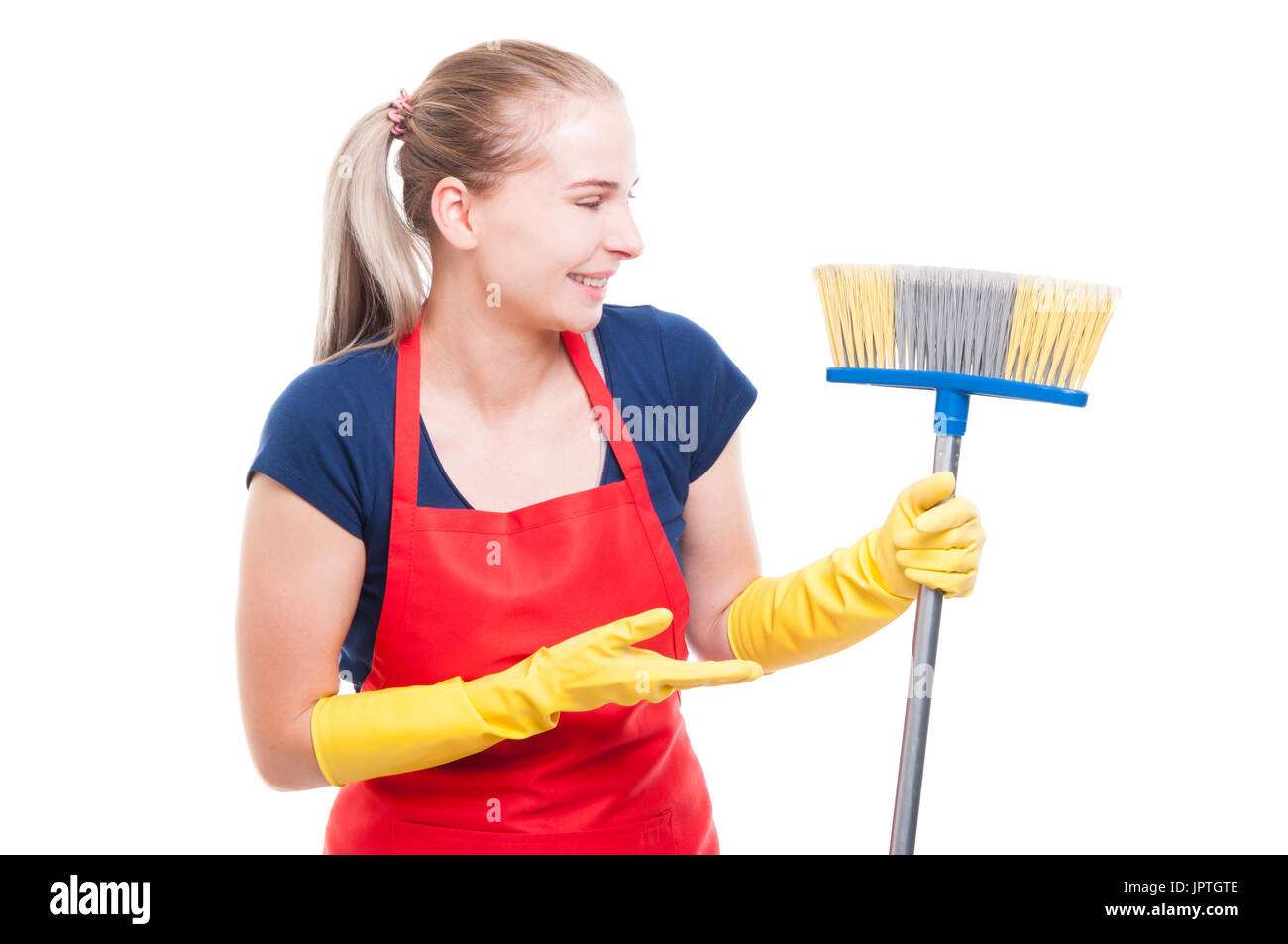 Pretty female cleaner showing her broom on white studio background ...