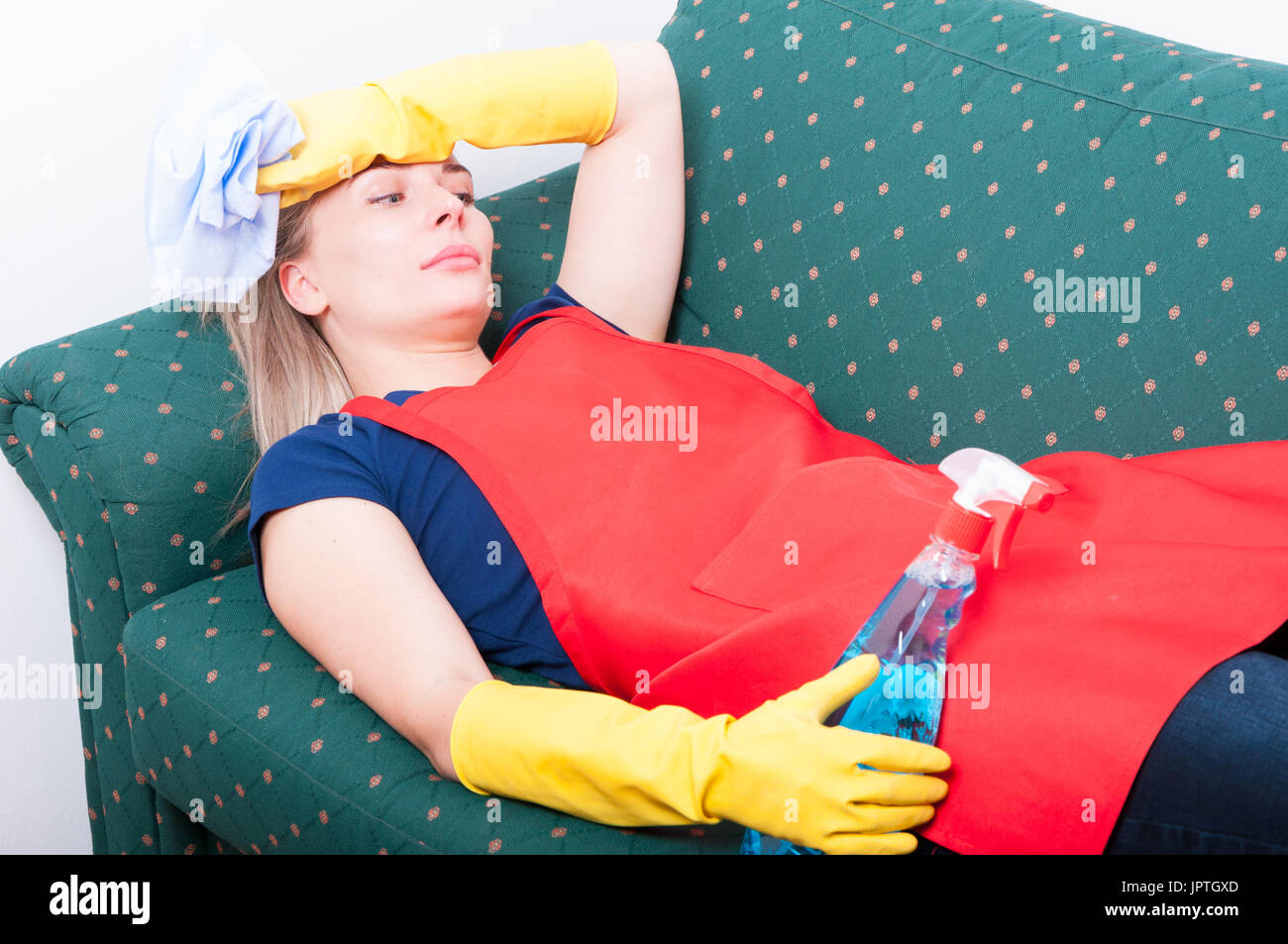 Young Maid With Cleaning Spray Laying On Couch Being Tired After