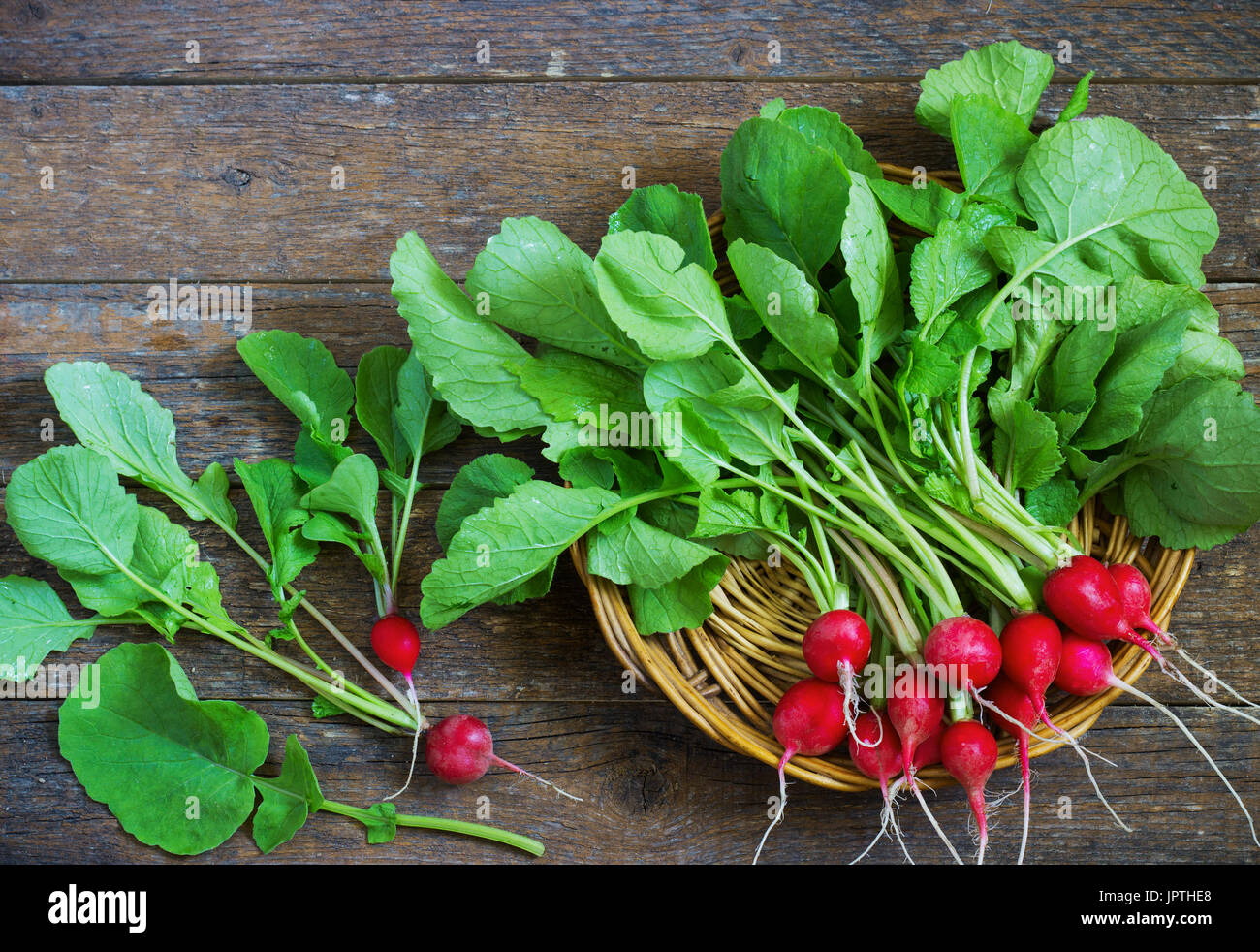 Fresh radishes on old wooden table in a wicker basket Stock Photo - Alamy