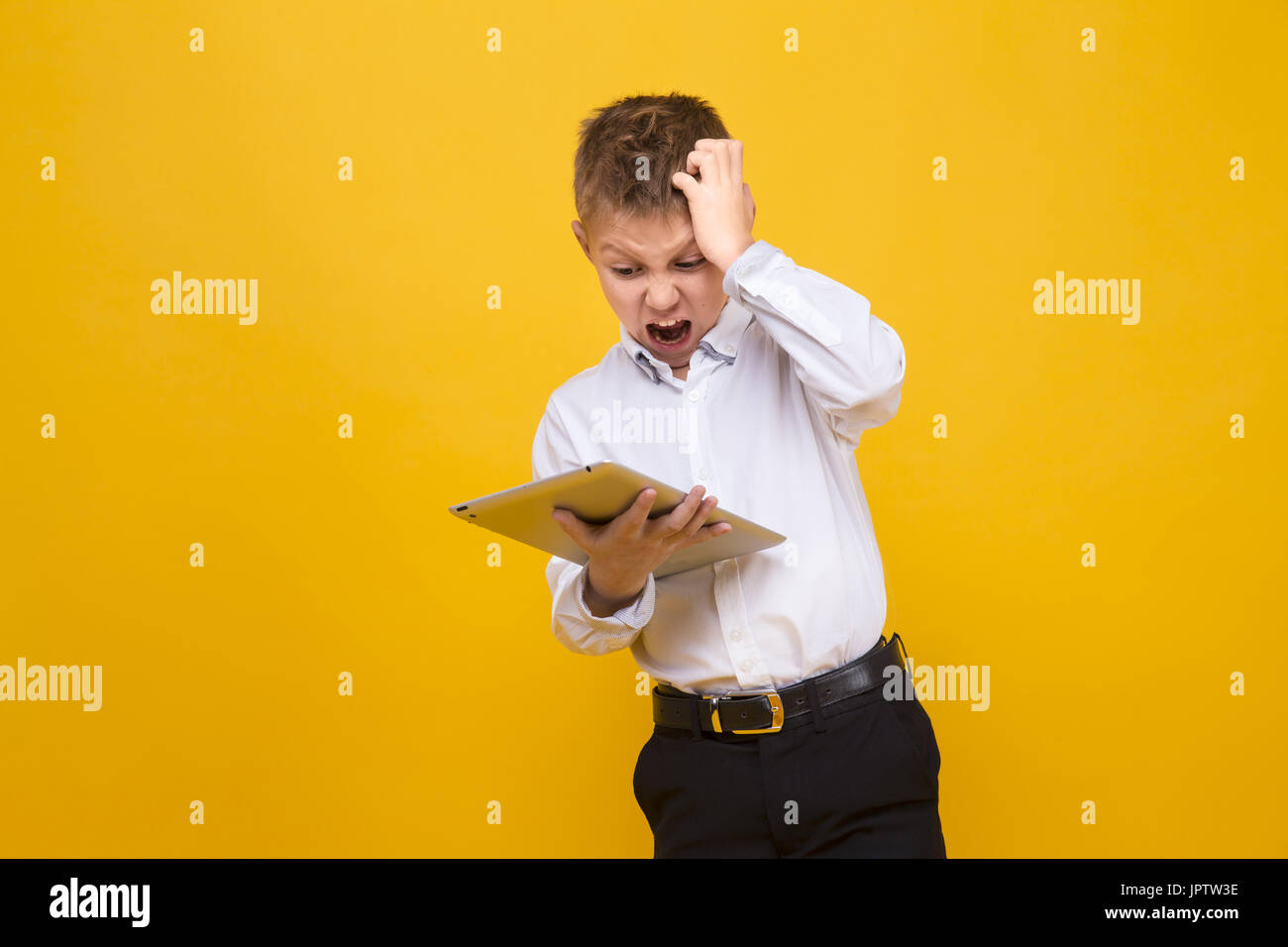 Furious boy posing with tablet Stock Photo - Alamy