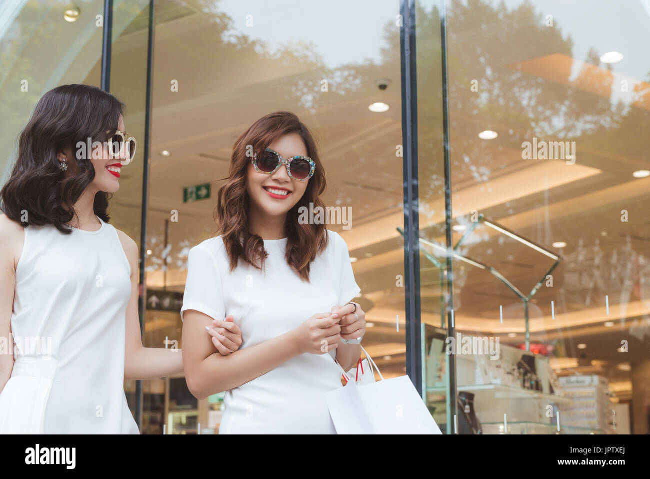 Young beautiful happy women with shopping bags on street at the mall ...