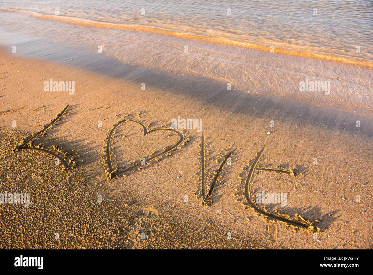 Love word written in sand. Summer beach concept Stock Photo - Alamy
