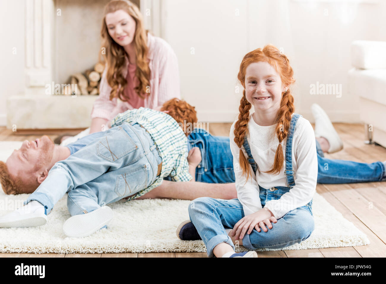 Beautiful happy redhead family having fun together on carpet, big ...