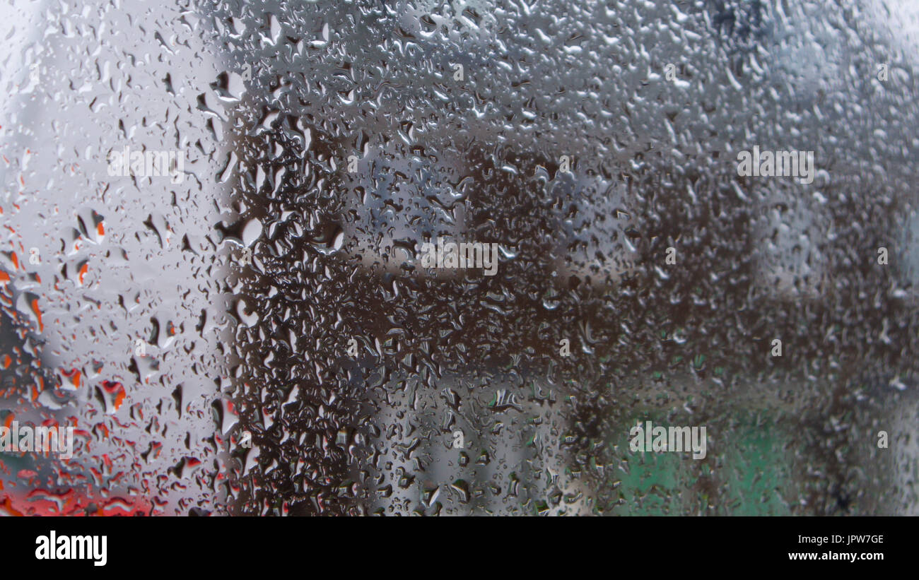Looking through a raindrop covered window at houses on a rainy summers ...