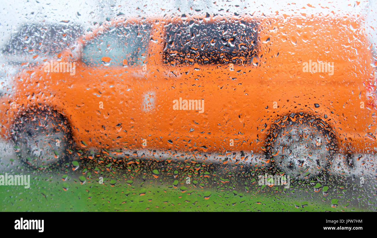 Looking through a raindrop covered window at houses on a rainy summers ...