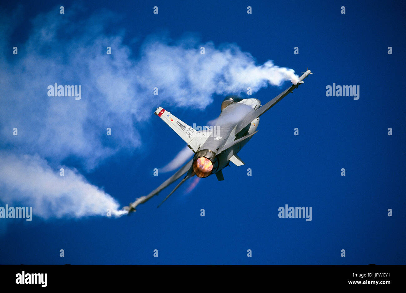 USAF F-16 Fighting Falcon fighter during a high-g flypast with smoke ...