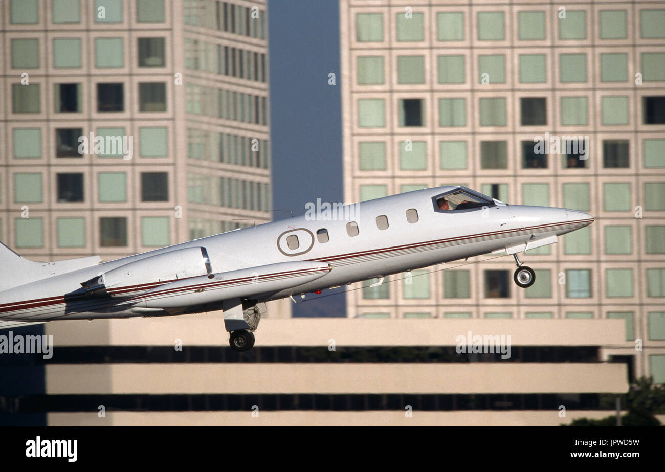Bombardier Learjet taking-off with office buildings behind Stock Photo ...