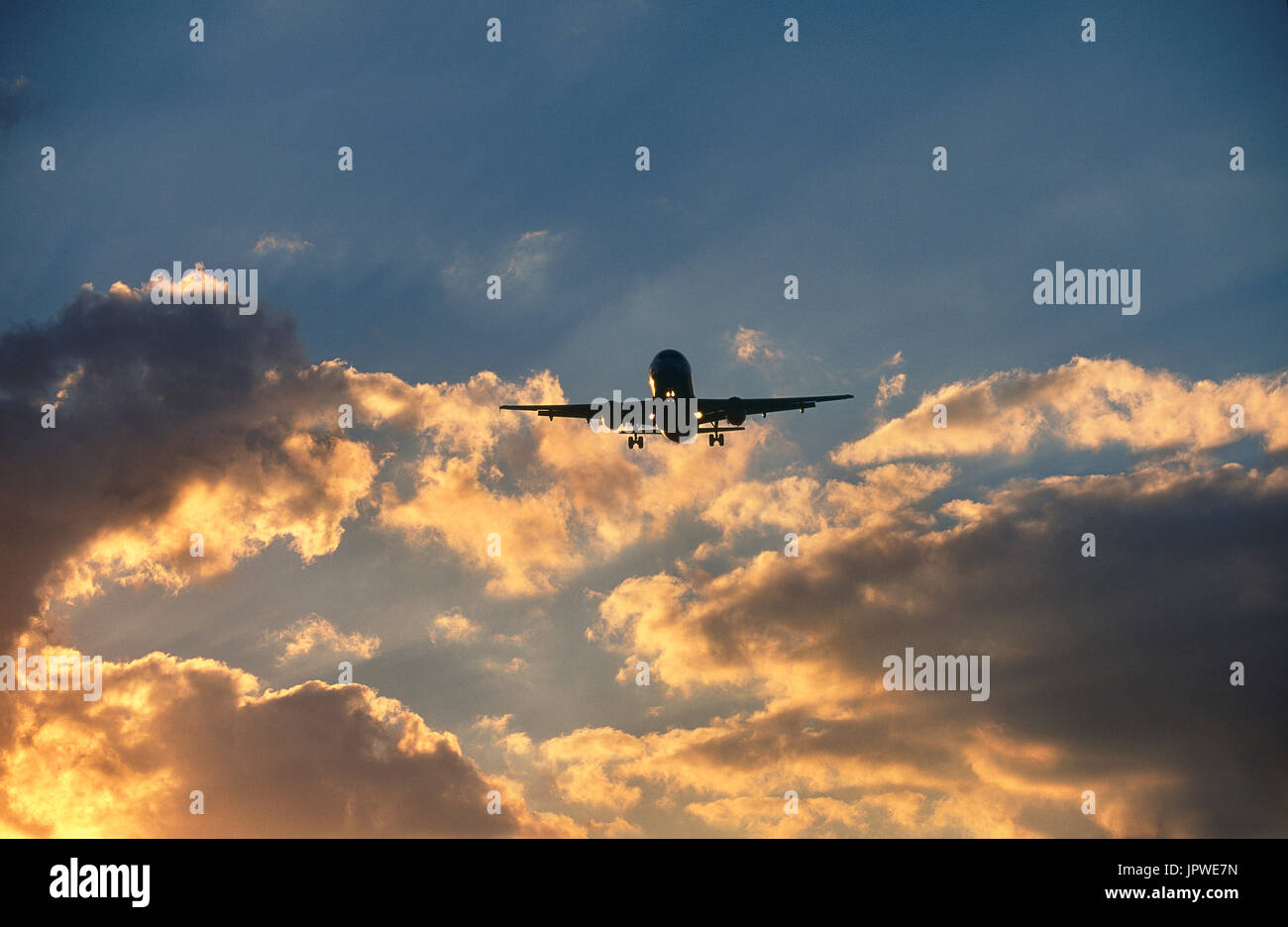 Airbus A320 on final-approach at dusk with flaps deployed and clouds ...
