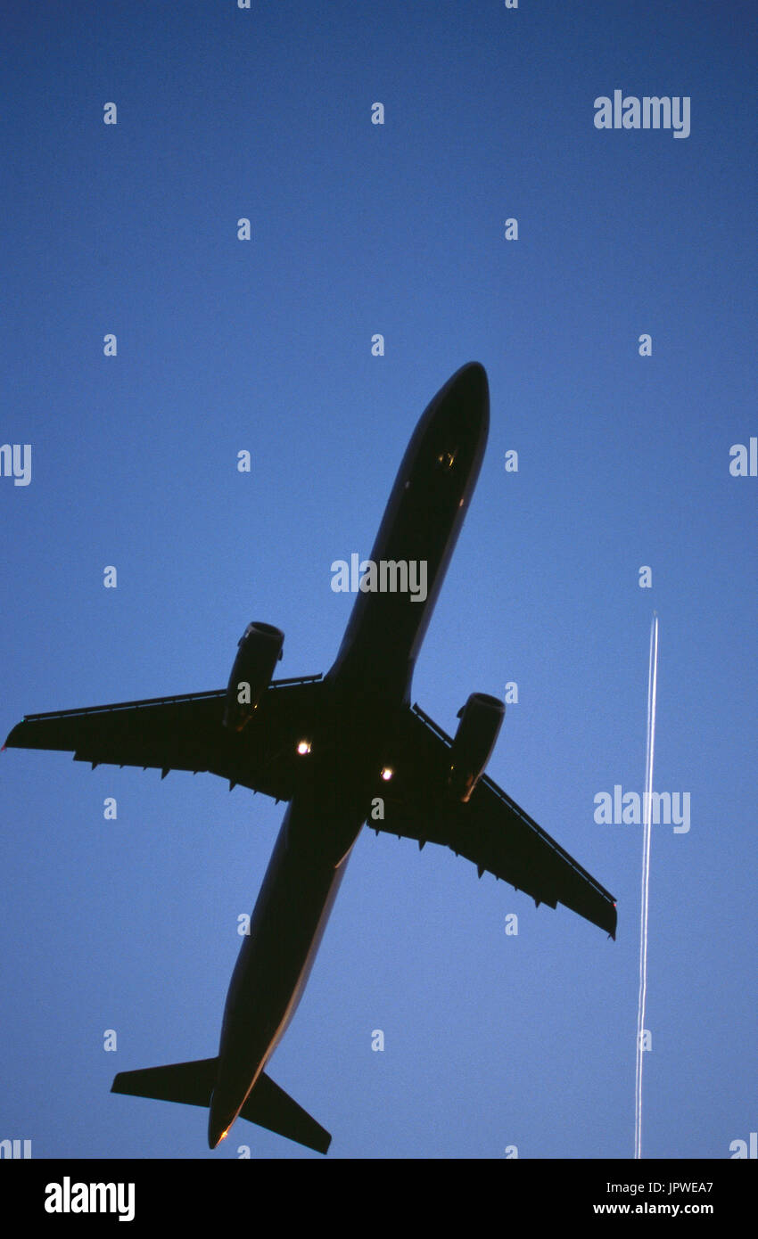 Airbus A321 climbing enroute at night with lights on and a contrail ...