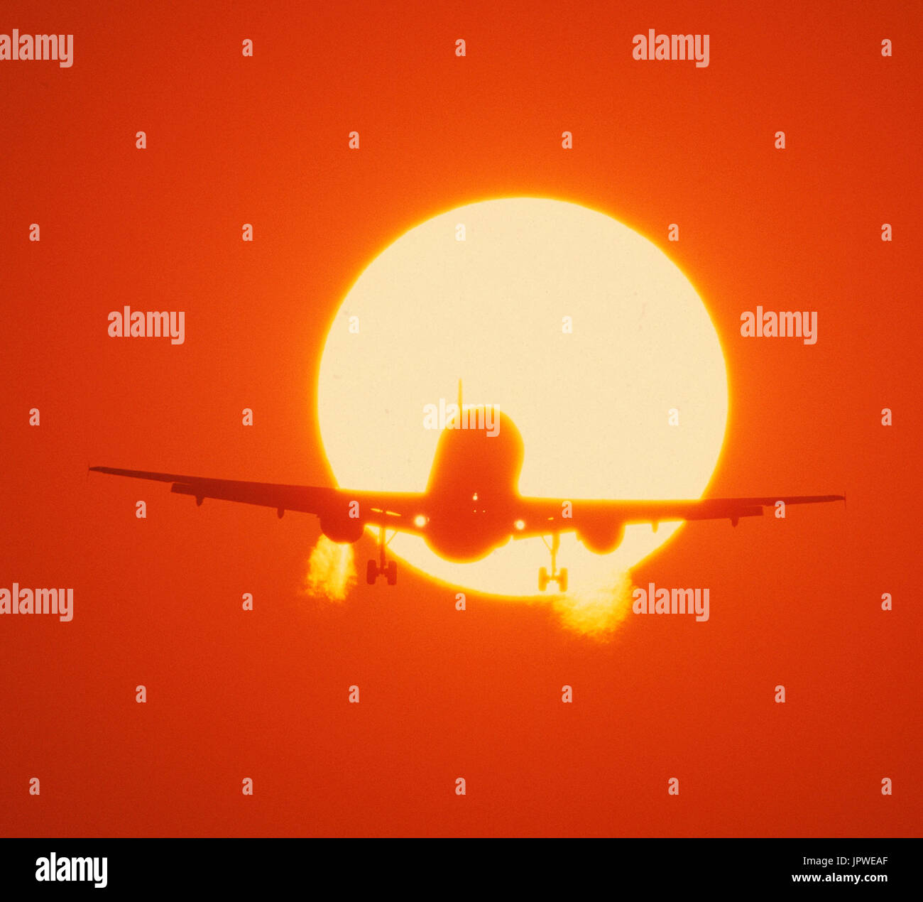 Airbus A320 on final-approach at sunset flying through the setting sun ...