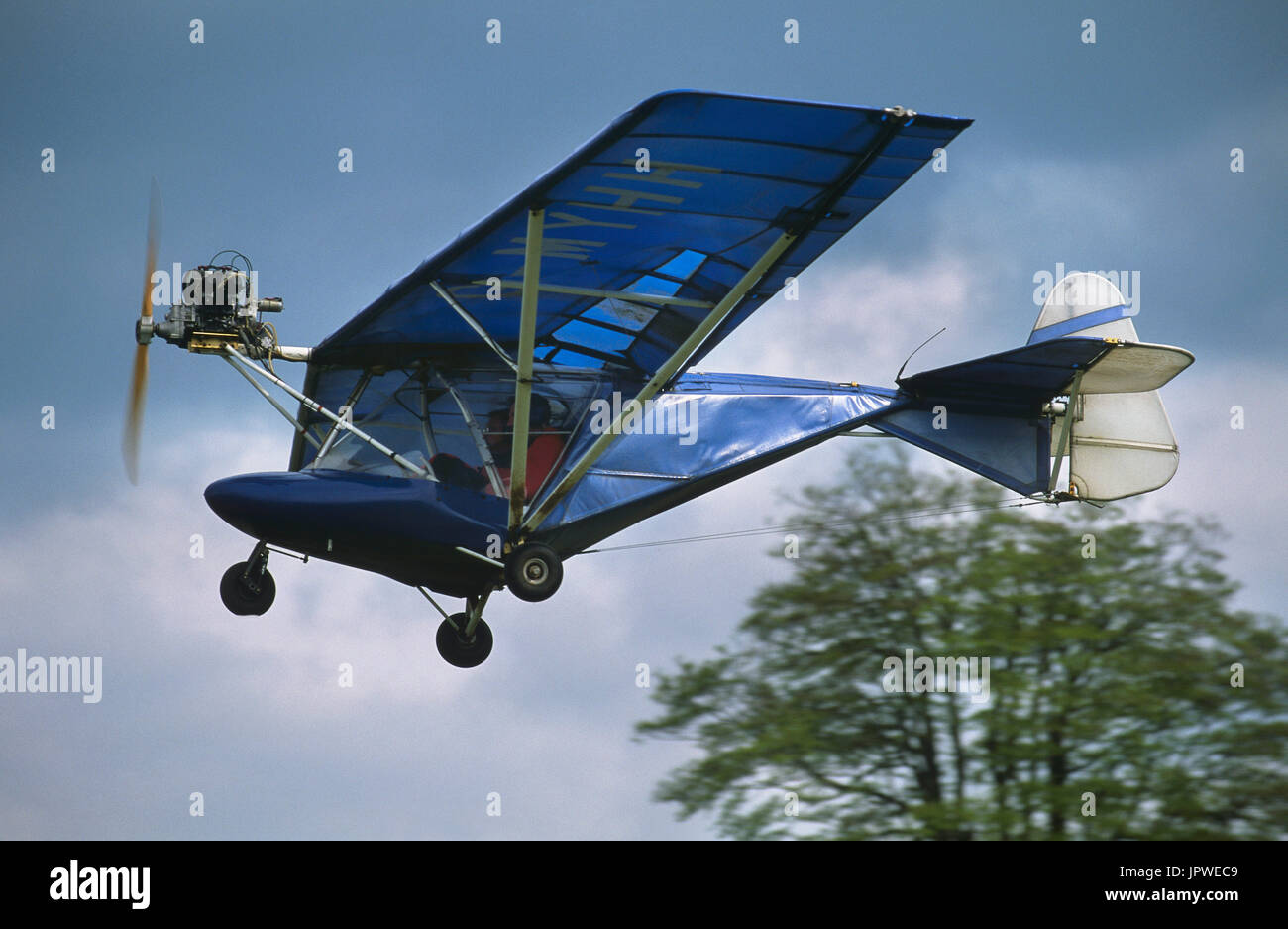Cyclone AX3-503 microlight taking-off past a tree Stock Photo - Alamy