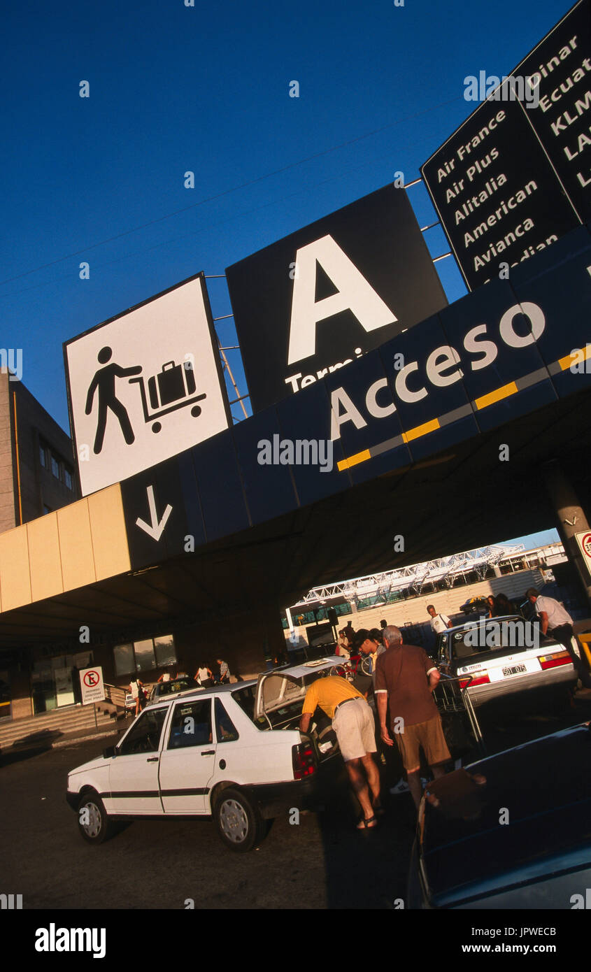 passengers and cars on a roads below an access and airline sign outside ...
