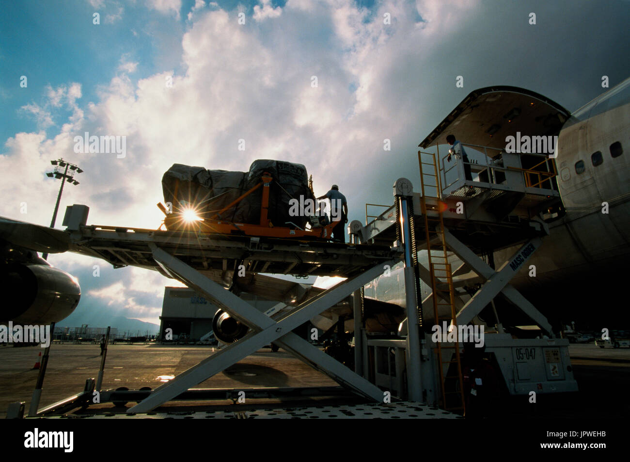 men loading cargo onto a Boeing 747-200 using a scissor-lift Stock ...
