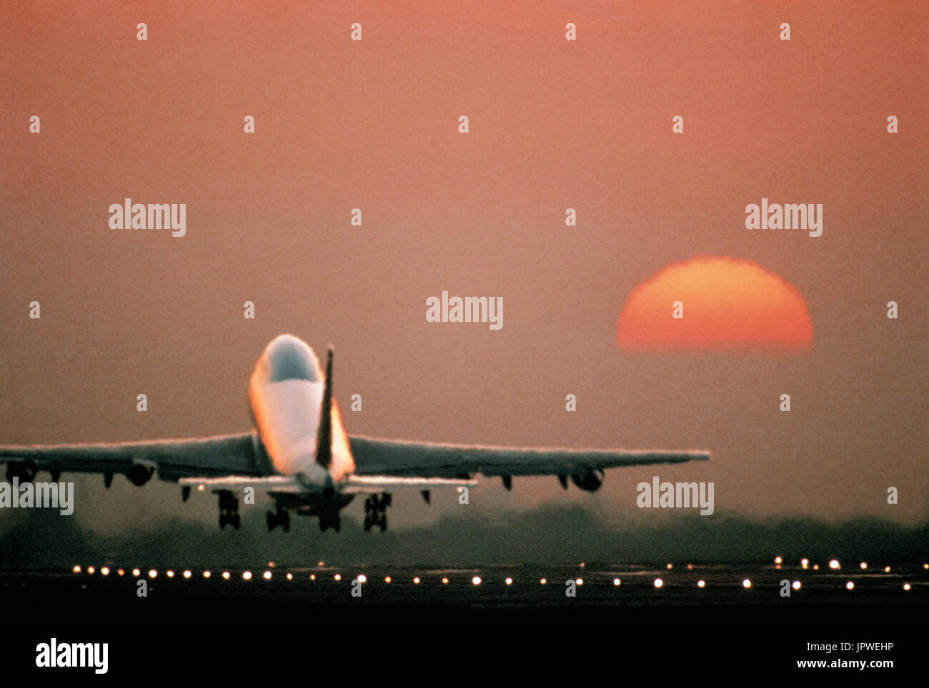 Boeing 747-200 taking-off at sunset with runway-lights on Stock Photo ...
