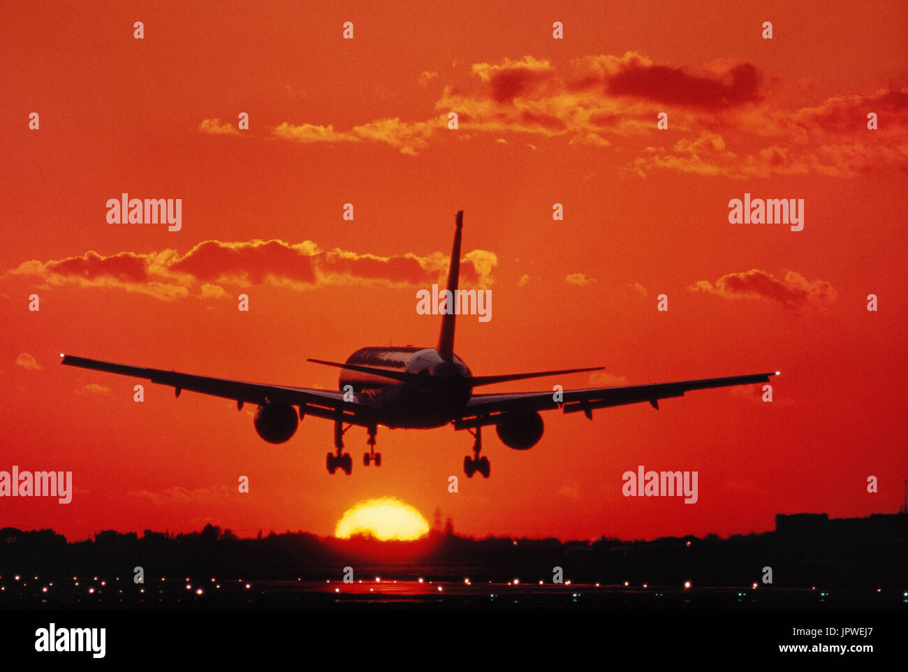 Boeing 757 landing on the runway with runway-lights on at sunset Stock ...