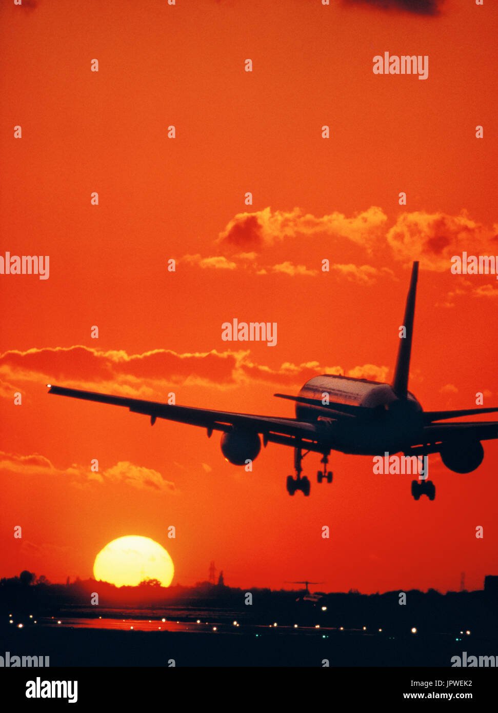 Boeing 757 landing on the runway at sunset with runway-lights on Stock ...