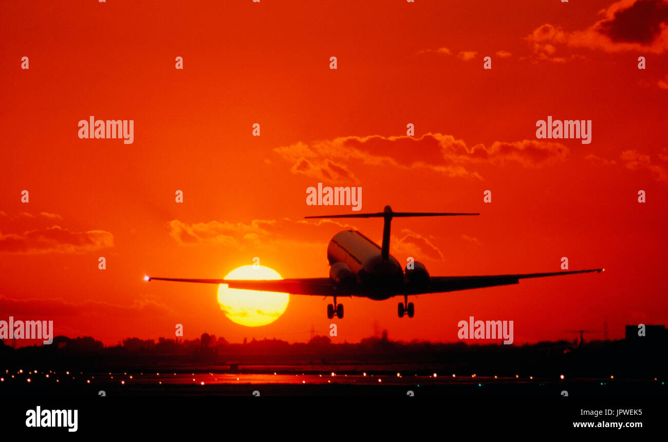 McDonnell Douglas MD-80 landing on the runway at sunset with runway ...