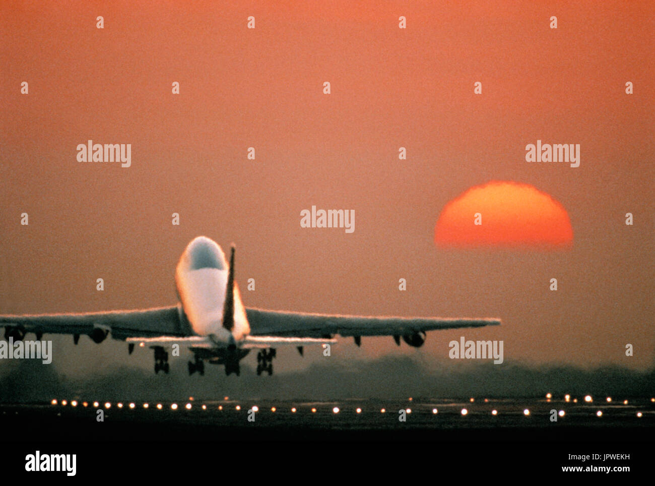 Boeing 747-200 taking-off at sunset from the runway with lights on ...