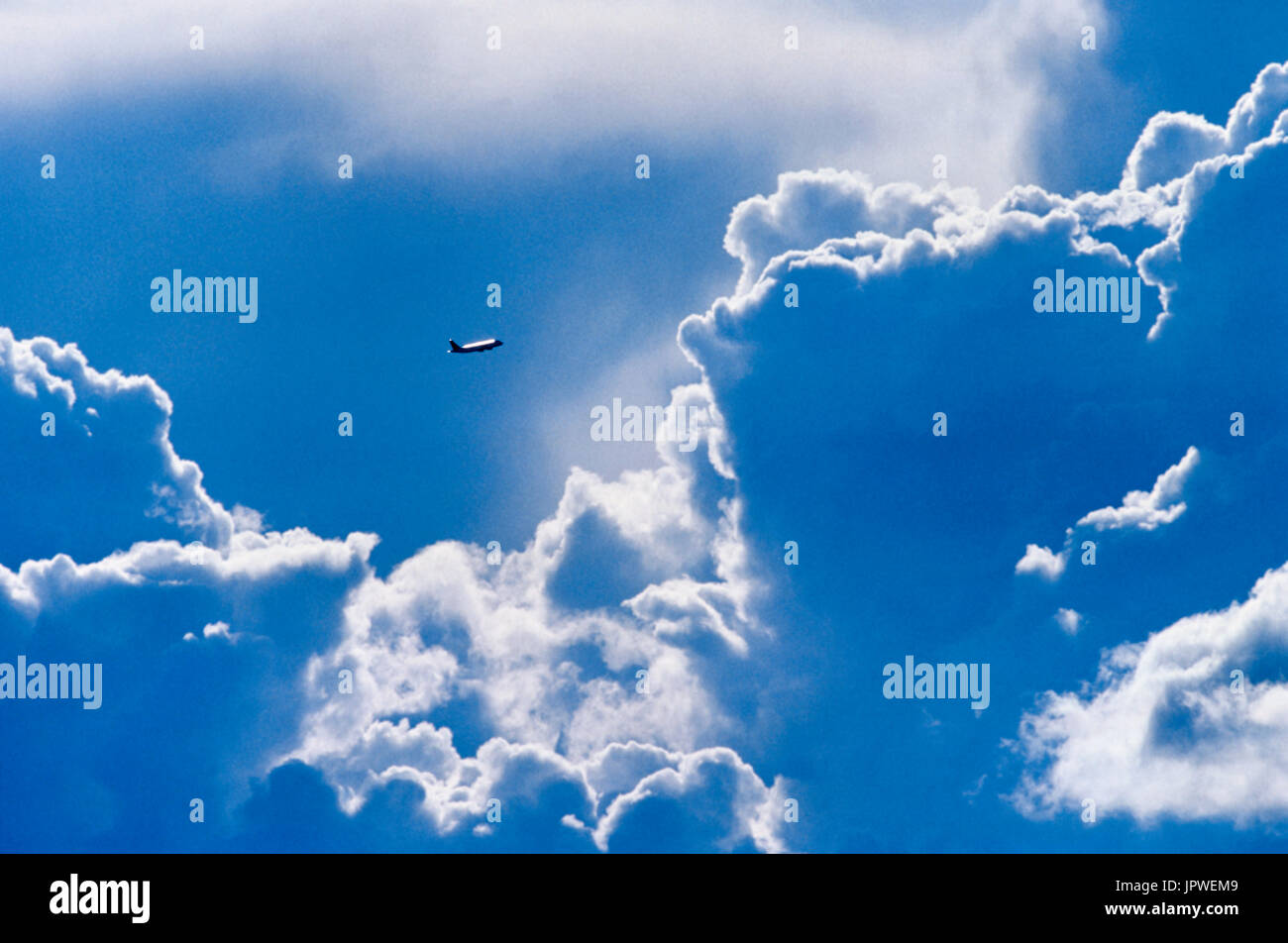 Airbus A320 flying enroute between towering-cumulus clouds Stock Photo ...
