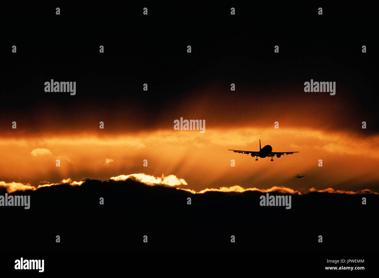Airbus A320 and a Bombardier DHC-8 (behind) final-approach at sunset ...