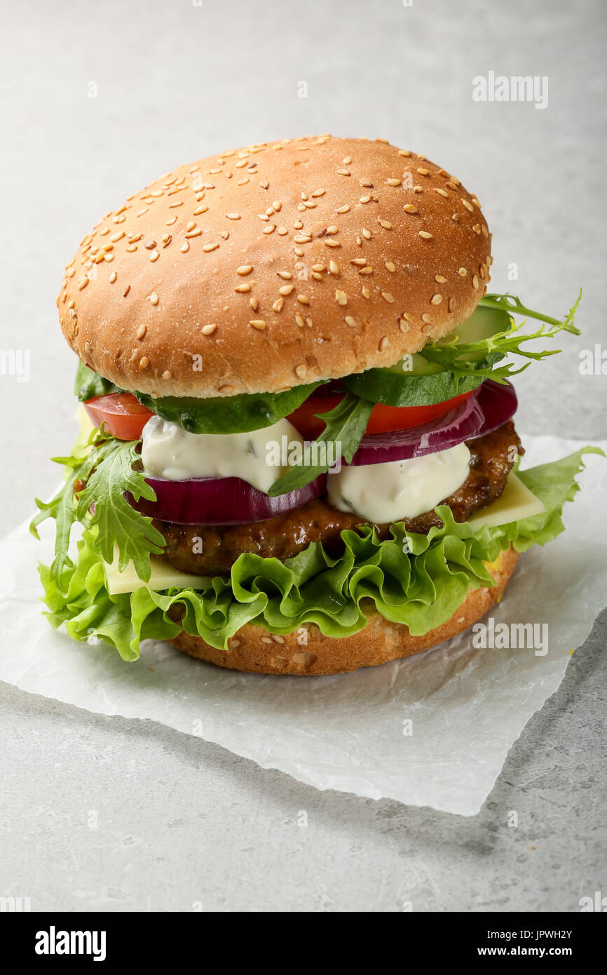 fresh tasty burger on gray background, food Stock Photo - Alamy