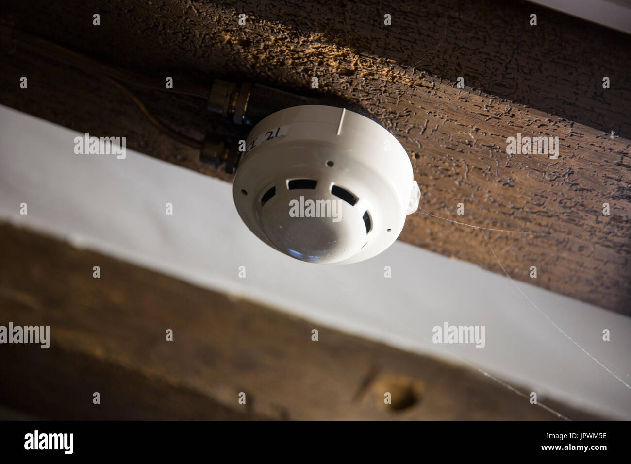 Smoke detector attached to a wooden beam of an old ceiling Stock Photo ...