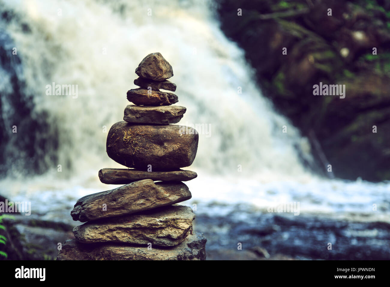 Stone pyramid near a tropical waterfall. The concept of harmony and ...